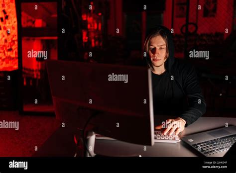 Portrait Of Wanted Hacker Man Stealing Information Preparing To Break Password Sitting At Desk