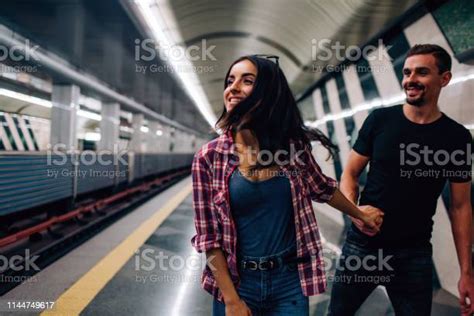 젊은 남성과 여성은 지 하를 사용 합니다 지하철에서 부부 남자와 젊은 여자의 쾌활 한 그림입니다 그는 손을 잡고 모델을 따른다 사랑 이야기 지 하 행동 관광에 대한 스톡