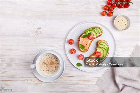 소금에 절인 연어 아보카도 크림 치즈 신선한 토마토 참깨 접시에 바질이 들어간 호밀 빵을 곁들인 건강한 토스트 생선과 커피 한 잔으로 만든 수제 아침 식사 호밀에 대한 스톡