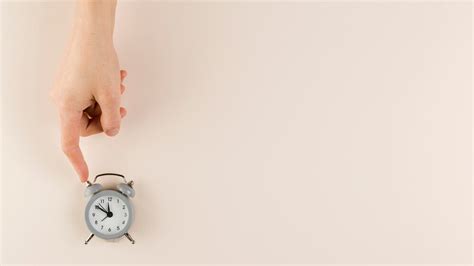 Free Photo Flat Lay Of Hand Holding Tiny Clock With Copy Space