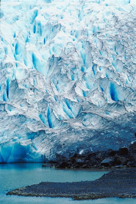 한 무리의 사람들이 물 옆 산 꼭대기에 서 있다 사진 Unsplash의 가장자리에 이미지