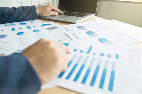 Premium Photo Businessman Analyzing Graphs And Using Laptop At Desk