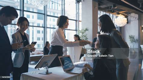 Asian Event Participants Guest Registering At Reception Desk Attending Business Conference