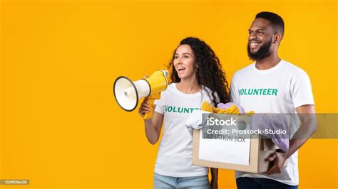 메가폰 노란 배경에서 말하는 기부 상자를 들고 있는 다민족 자원봉사자들 자원봉사에 대한 스톡 사진 및 기타 이미지 자원봉사 휴대용 마이크 2명 Istock