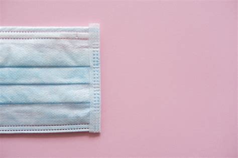 분홍색 배경에 고립 된 파란색 의료 보호 마스크 코로나바이러스를 방지하기 위해 입과 코를 덮는 일회용 3ply 의료 용 마스크 박테리아에서 시술 마스크 코로나바이러스 검역