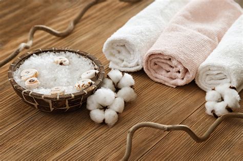 그릇에 흰 바다 소금과 나무 질감 표면에 부드러운 푹신한 수건 스파 구성 목욕을 위한 바다 소금 3가지 개체에 대한 스톡 사진