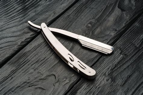 Premium Photo Sharp Shaving Razor On Black Wooden Background