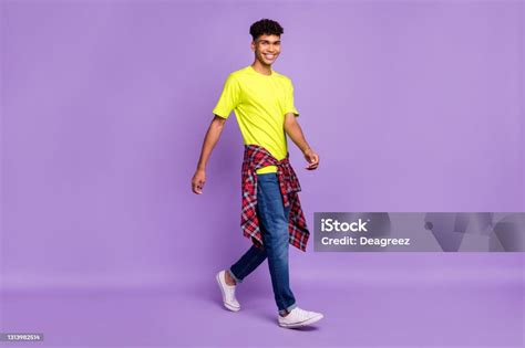 전신 프로필 측면 사진 의 젊은 잘 생긴 흑인 남자 행복 한 미소 이동 걸어 고립 된 보라색 색상 배경 T 셔츠에 대한 스톡