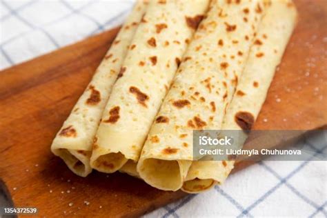 부드러운 나무 판에 버터와 설탕이 있는 홈메이드 노르웨이 감자 플랫브레드가 낮은 각도로 보이는 소박한 나무 판에 놓입니다