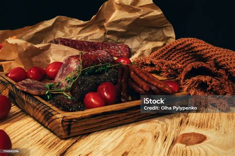 녹색 종이와 토마토가 든 나무 쟁반에 다양한 종류와 크기의 소시지 어두운 배경에 훈제 소시지 세트 가공육에 대한 스톡 사진 및 기타 이미지 Istock