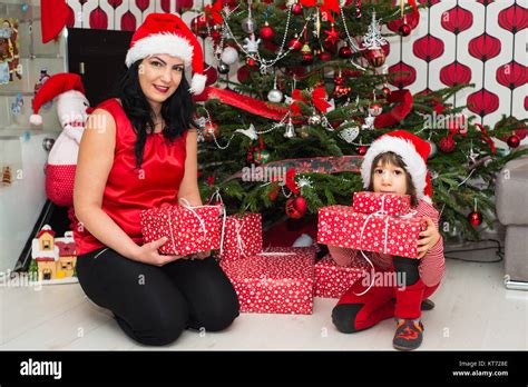 Mother And Son In Front Of Xmas Tree Holding Presents And Posing Together Stock Photo Alamy