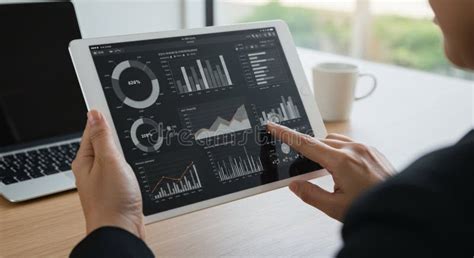 A Person Is Holding A Tablet Displaying Various Data Visualizations Including Bar Stock