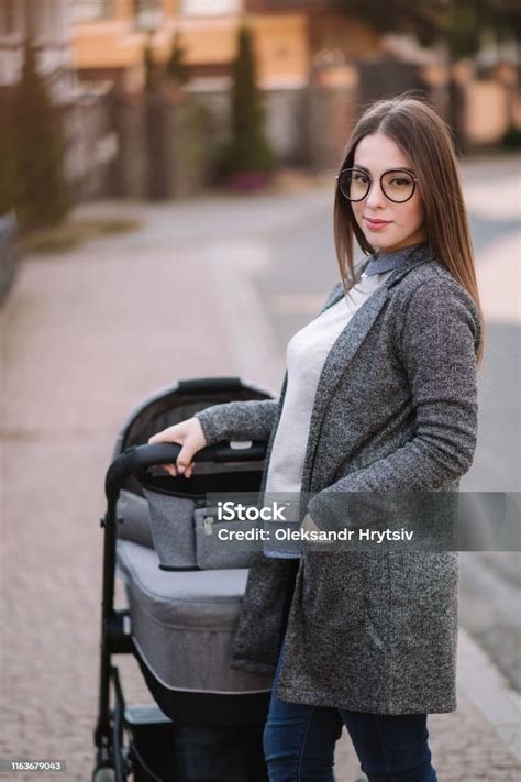 매력적인 젊은 어머니는 그녀의 작은 아기와 함께 걷고있다 유모차에 신생아와 엄마 가족에 대한 스톡 사진 및 기타 이미지 가족