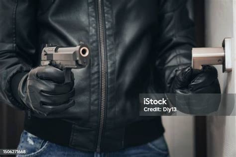Dhrt 권총을 든 무장 범죄자가 구내에 들어갑니다 강도 시도 범죄 개념입니다 은행 강도 총기로 자기 방어 남자는 총을 등 뒤에 숨 깁니다 Brand Name Video