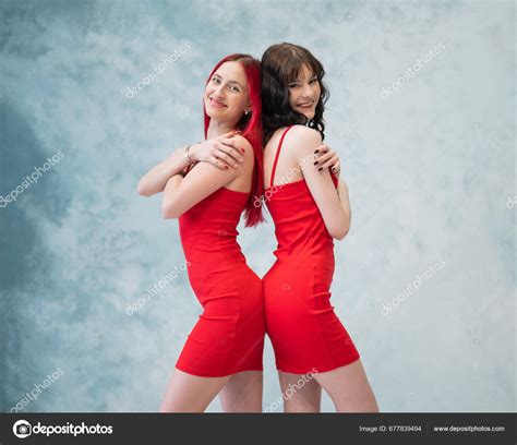 Portrait Two Women Dressed Identical Red Dresses Standing Back Back