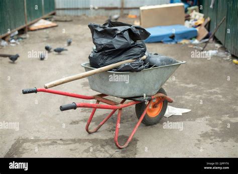 Garden Cart With Black Bags Inside Cleaning Of Territory Transportation Of Garbage Garbage Garden Cart With Black Bags Inside Cleaning Of Territory Transportation Of Garbage Garbage