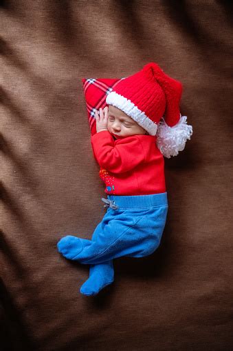 산타 모자에 귀여운 신생아 어두운 배경에 아기를 자고 신생아의 클로즈업 초상화 아기 상품 포장 템플릿 보육 의료 및 건강 한 개념 크리스마스 새해 12월에 대한 스톡 사진