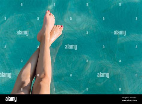 Crop Anonymous Barefoot Female Travelers Touching Shiny Rippled Water