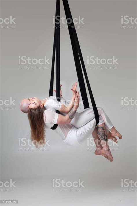 아름다운 소녀와 흰색 스포츠 정장에 운동 남자는 스튜디오에서 곡예 요소를 수행하고있습니다 가냘픈에 대한 스톡 사진 및 기타 이미지 가냘픈 건강한 생활방식 공연자