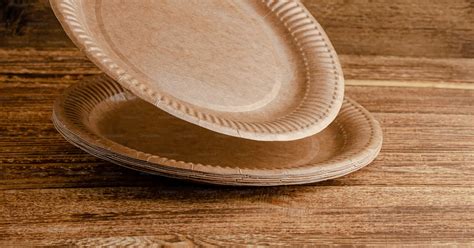 나무 배경에 일회용 종이 식기를 날리고 있습니다 환경 보호 개념입니다 공간을 복사합니다 사진 Unsplash의 종이 이미지