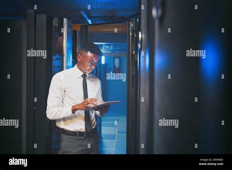 Lets Run Diagnostics A Young It Specialist Standing Alone In The Server Room And Using A