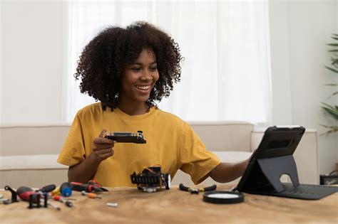 웃는 젊은 여성은 집에서 태블릿으로 장난감 로봇 기술을 배우고 있다 학교 교실에서 로봇 장난감 자동차를 만드는 젊은 여성 교육 및 기술 개념 20 24세에 대한 스톡 사진