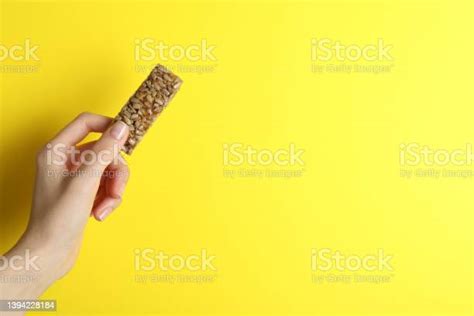 노란색 배경에 코지나키 바를 들고 있는 여자 클로즈업 텍스트를 위한 공간 꿀에 대한 스톡 사진 및 기타 이미지 꿀 노랑 달콤한 음식 Istock
