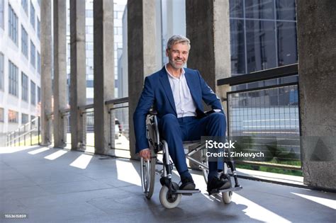 Gray Haired Disabled Man Wearing Official Style Suit In Wheelchair City