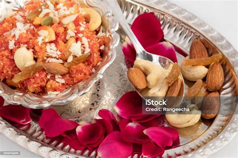 가자르 카 할와 할바 또는 당근 푸딩 할루아 갈은 당근 밀크 크림 Meetha Mava 설탕 데시 코야 마와 와 바담 카주 같은 건조 과일은 꽃 장식 장미와 실버 그릇에