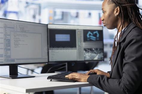 Woman Coding At Computer Desk In Solar Panels Manufacturing Plant Stock