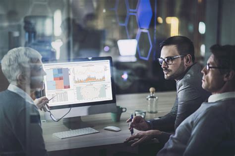 사무실에서 데스크톱 Pc에서 작업하는 동안 차트에 대해 이야기하는 비즈니스 동료 경영자에 대한 스톡 사진 및 기타 이미지