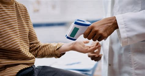 의료 클리닉에서 어린이의 체온을 측정하는 동안 적외선 온도계를 사용하여 의사를 닫습니다 사진 Unsplash의 세르비아 이미지