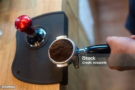 기계 홀더에 커피를 누르는 바리스타 커피 변조에 커피 분말 변조를 사용하여 지상 커피를 포르타필터로 눌러 에스프레소 핫 드링크 음료를 만듭 가루로 빻은에 대한 스톡 사진 및