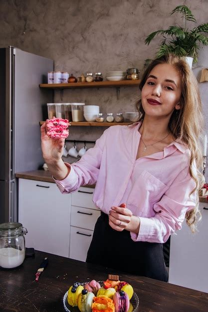 Premium Photo A Woman In A Pink Shirt Holds A Cookie In Her Hand And She Is Holding A Cookie