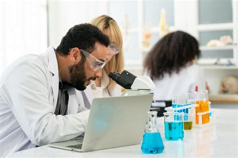 Premium Photo Lab Worker Using Magnifying Glass On Microscope
