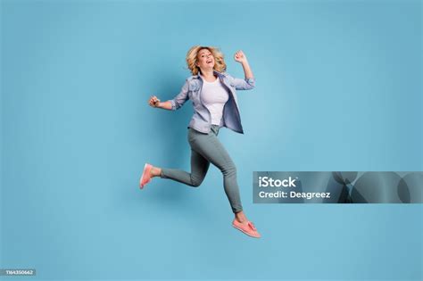 파란색 배경 위에 고립 된 바지바지를 입고 웃는 팔을 올리는 사랑스러운 매력적인 사람의 전체 길이 사진 여자에 대한 스톡 사진 및 기타 이미지 Istock