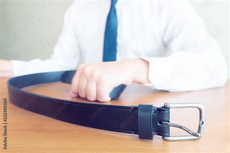 Office Man In White Shirt And Tie Is Holding A Belt Punishment Concept