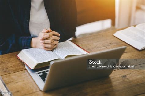 그리스도인 여성은 손을 잡고 성경을 읽고 하나님께 기도하고 예배합니다 나무 식탁에서 더 나은 삶을 살기를 바라는 하나님의 축복을 위해 기도하십시오 선함을 믿는 그리스도인의