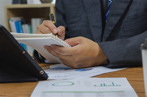 펜 문서 그래프 회계 재무 종이 작업 분석 차트 마케팅 투자 및 사무실에서 책상에 컴퓨터 노트북으로 경제를보고하는 사업가 개념에