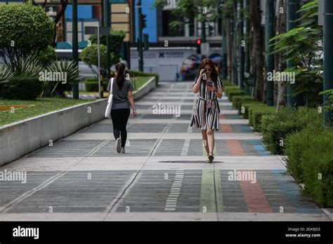 People Walk Along An Almost Empty Pedestrian Lane Inside A Business District In Manila