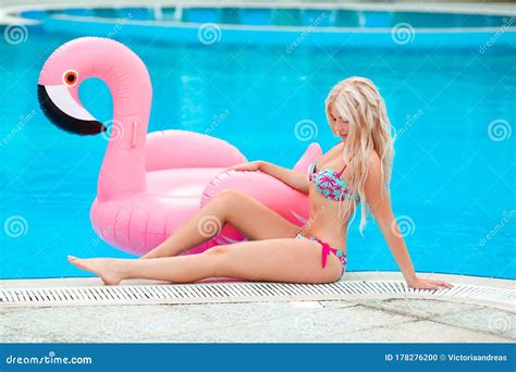 Fashion Blond Model Woman In White Bikini Posing On Pink Inflatable
