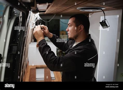Side View Portrait Of Man Building Camper Van And Installing Wires For Electrics Stock Photo Alamy