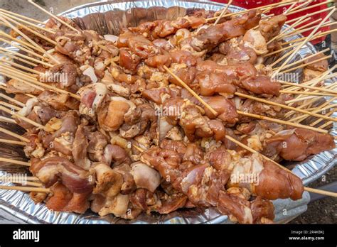 A Large Tray Of Filipino Barbecue Marinated Pork Pushed Onto Skewers