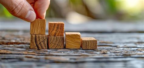 Premium Photo Hand Stacking Wooden Blocks In A Balanced Structure