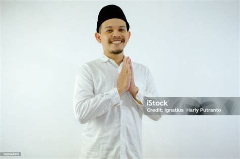 흰 옷을 입은 아시아 무슬림 남성이 라마단과 이드 알 피트르 축제 기간 동안 하얀 배경 위에 서서 인사를 하기 위해 웃고 있다 30 34세에 대한 스톡 사진 및 기타 이미지