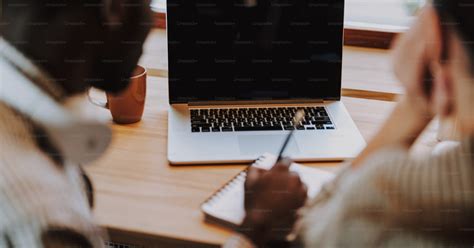 노트북 위에 서 있는 최신 노트북과 그 앞에 앉아 메모를 하는 두 명의 학생 사진 Unsplash의 흑인 남성 이미지