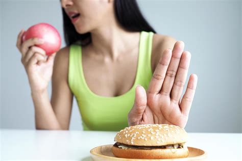 Asian Women Push The Hamburger Plate And Choose To Eat Apples For Good