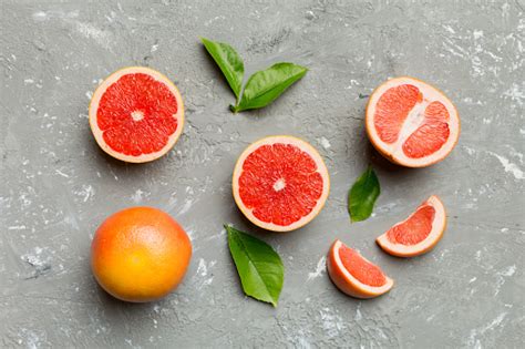 색으로 칠해진 배경에 육즙이 많은 자몽 슬라이스가 있는 신선한 과일 자몽 맨 위 보기입니다 공간을 복사합니다 창조적 인 여름 개념 복사 공간이있는 최소한의 평평한 평지에