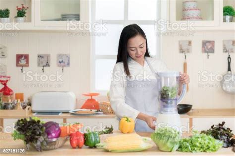 야채 스무디입니다 아시아 여자 만들기 녹색 스무디 블렌더로 부엌에서 집 건강 한 원시 먹는 라이프 스타일 개념의 초상화 시금치 당근 셀러리 등 음료를 준비 하는 아름 다운