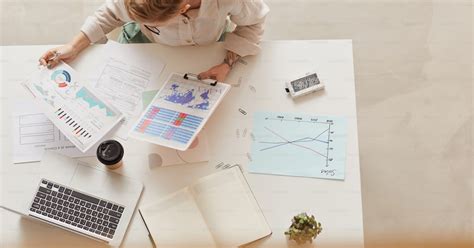 테이블에 앉아 있는 동안 데이터 차트를 들고 있는 현대 사업가의 배경 위 복사 공간 사진 Unsplash의 종이 이미지